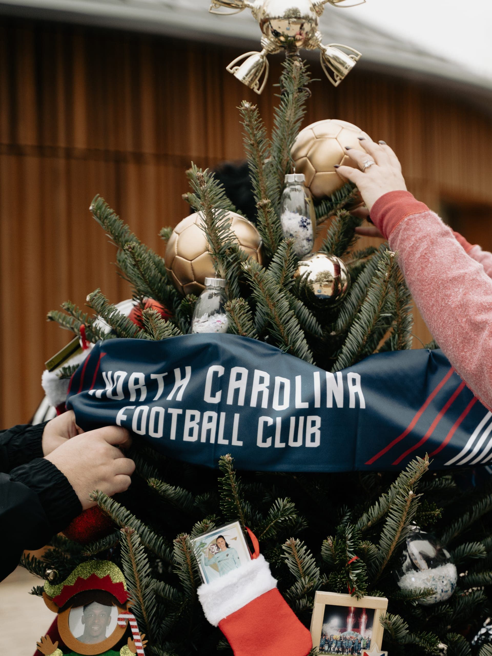 North Carolina Football Club staff decorates tree for Gifting Tree ...